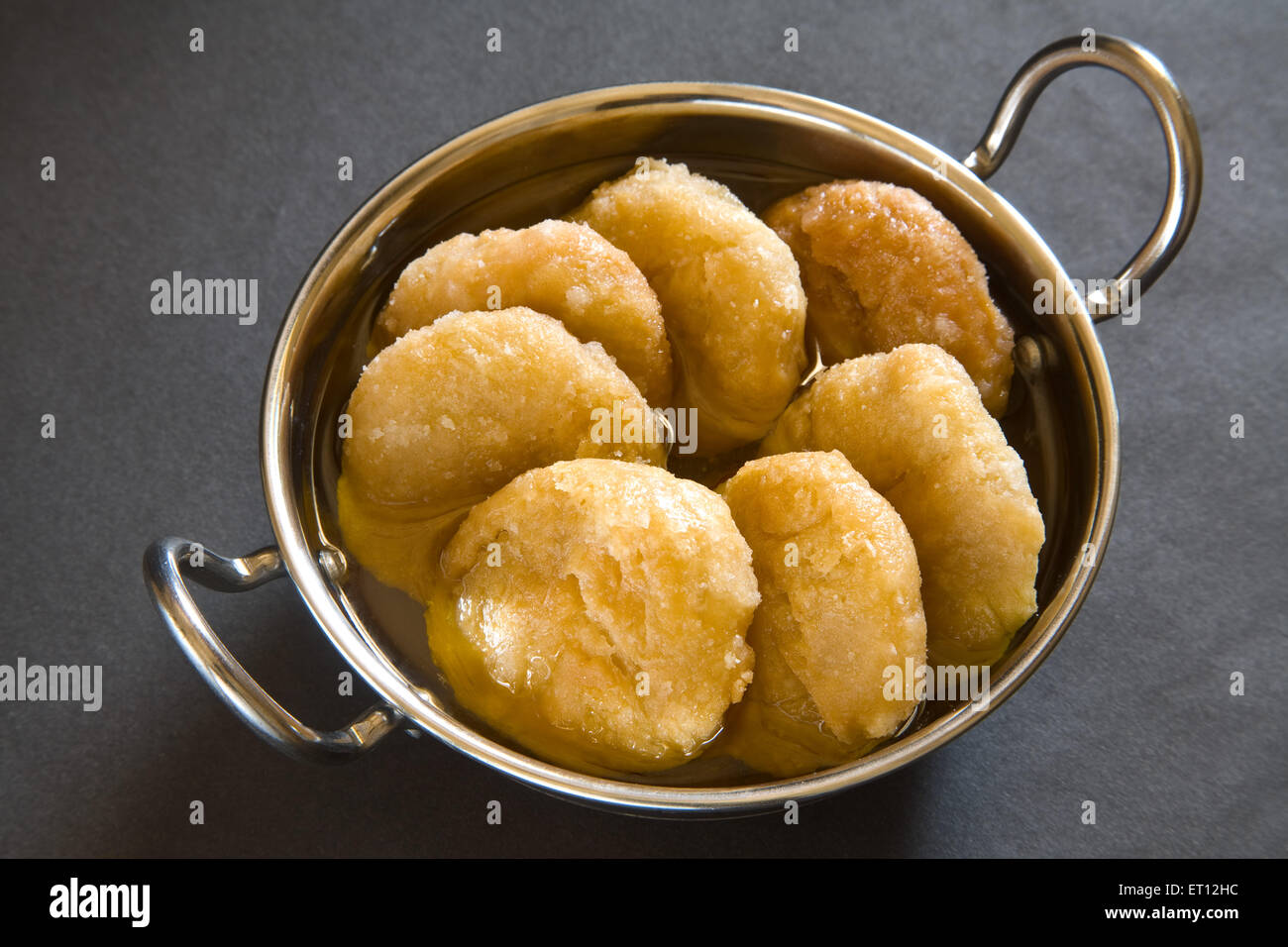 Indian sweet ghari ghaari dipping in sugar syrup in steel kadai on ...