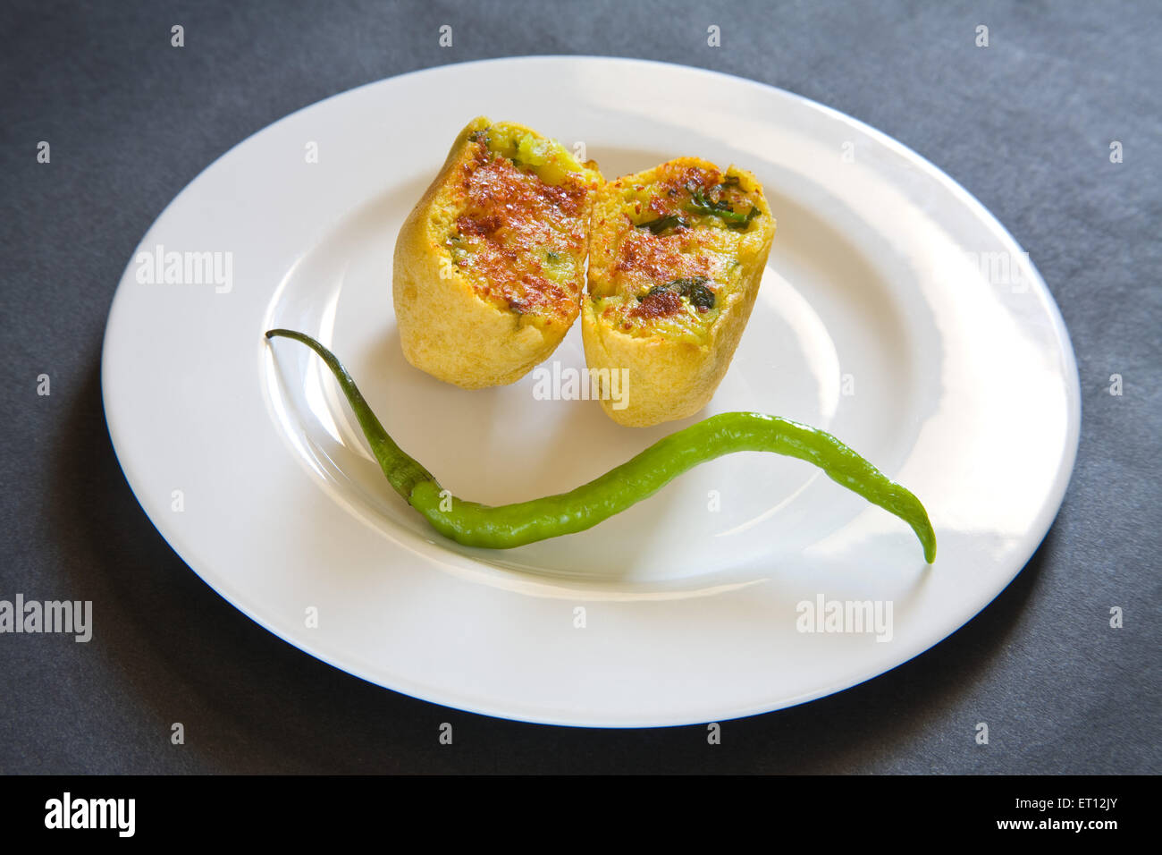 Indian fast food fried batata potato vada with red chutney and green ...