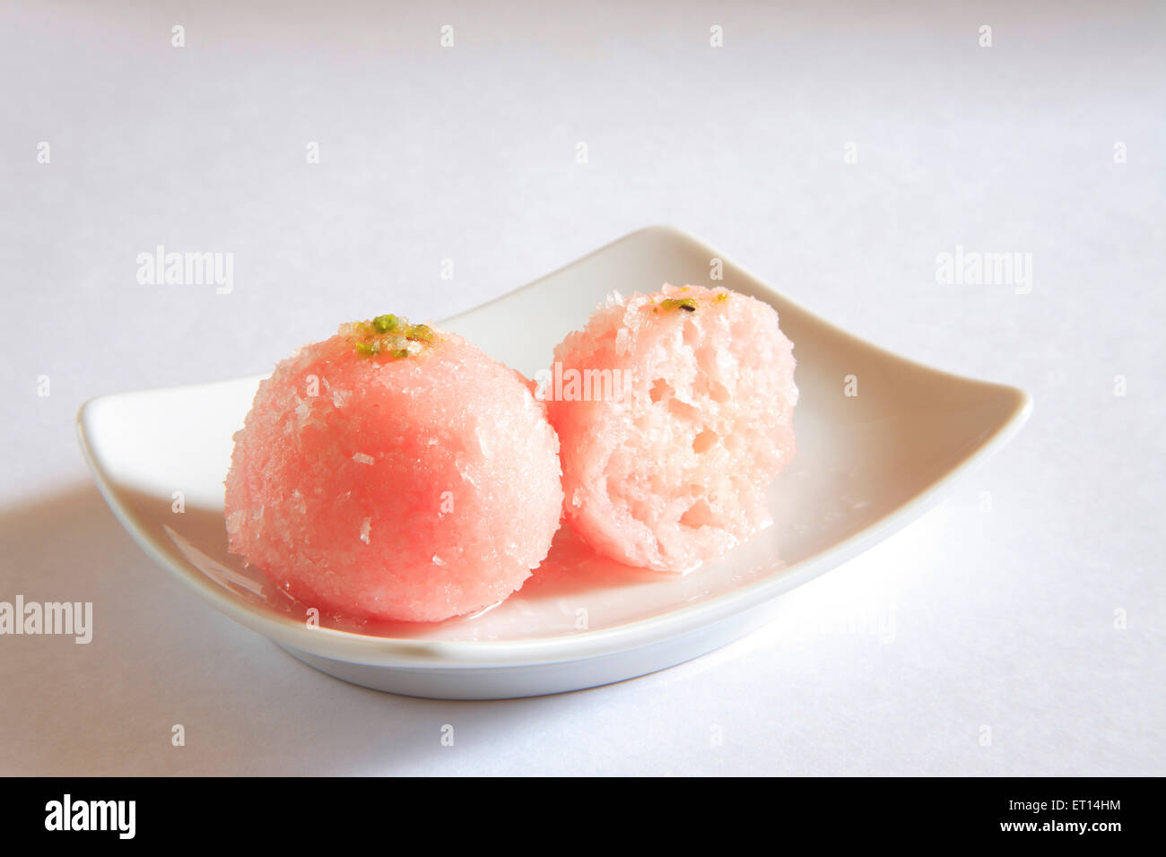 One and half piece of bengali mithai raskadam garnish with coconut and ...