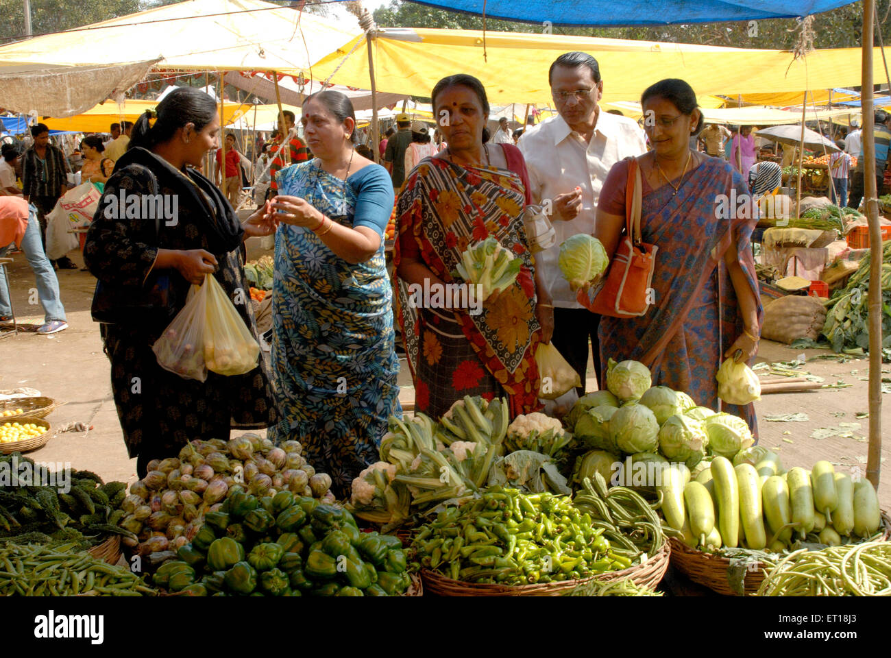 Women purchasing vegetable from market ; Devlali ; Maharashtra ; India ...