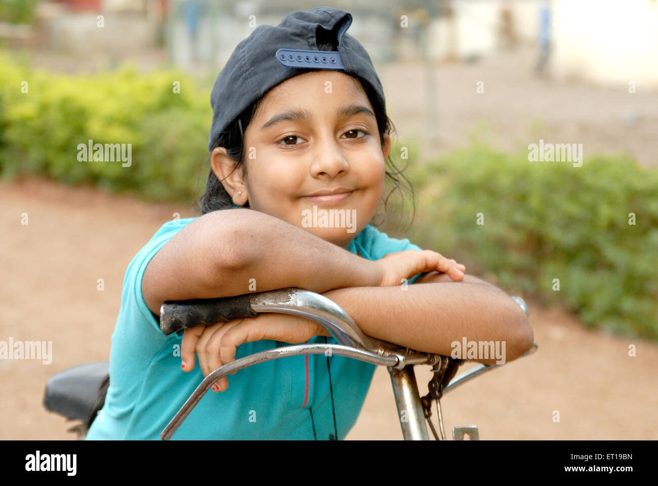 Young Indian girl resting hands on bicycle wearing reverse cap - MR#152 ...