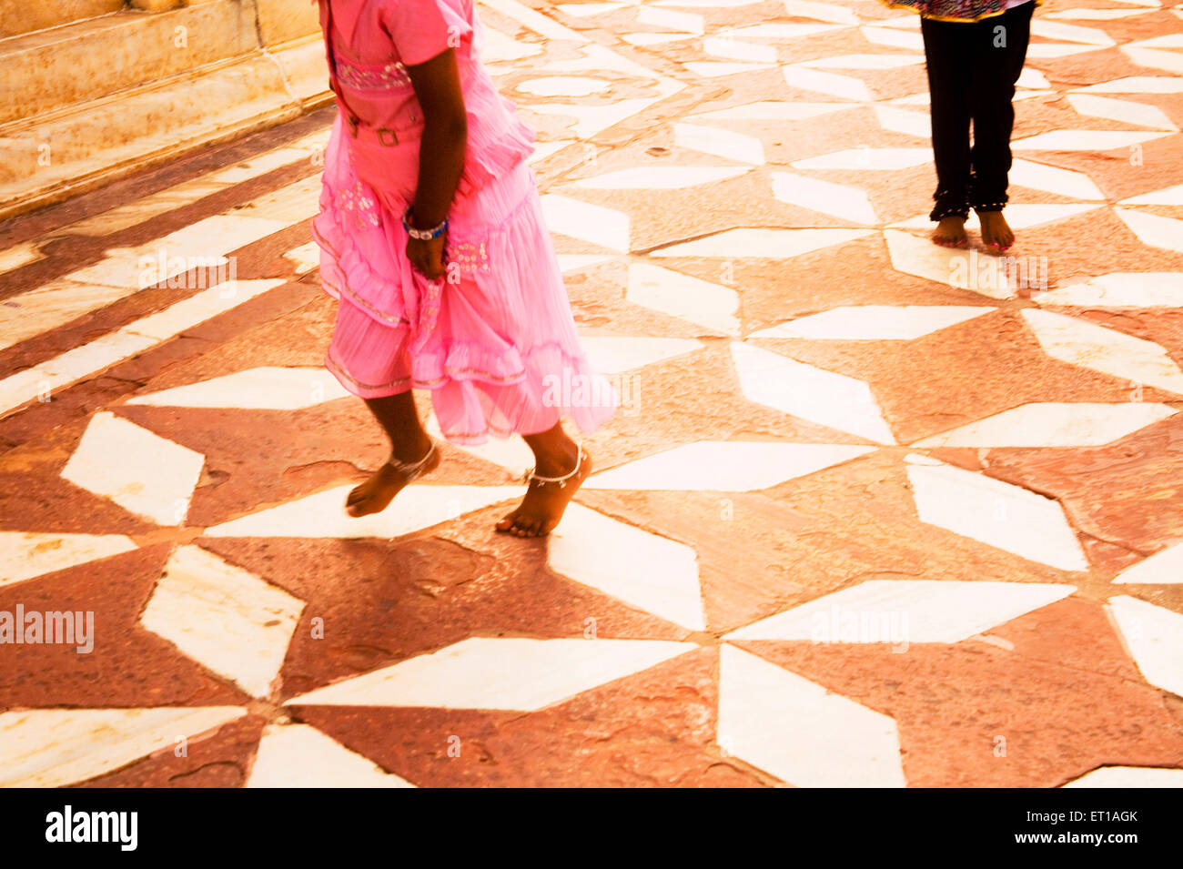 Indian girl wearing pink color frock jumping on the floral pattern of ...