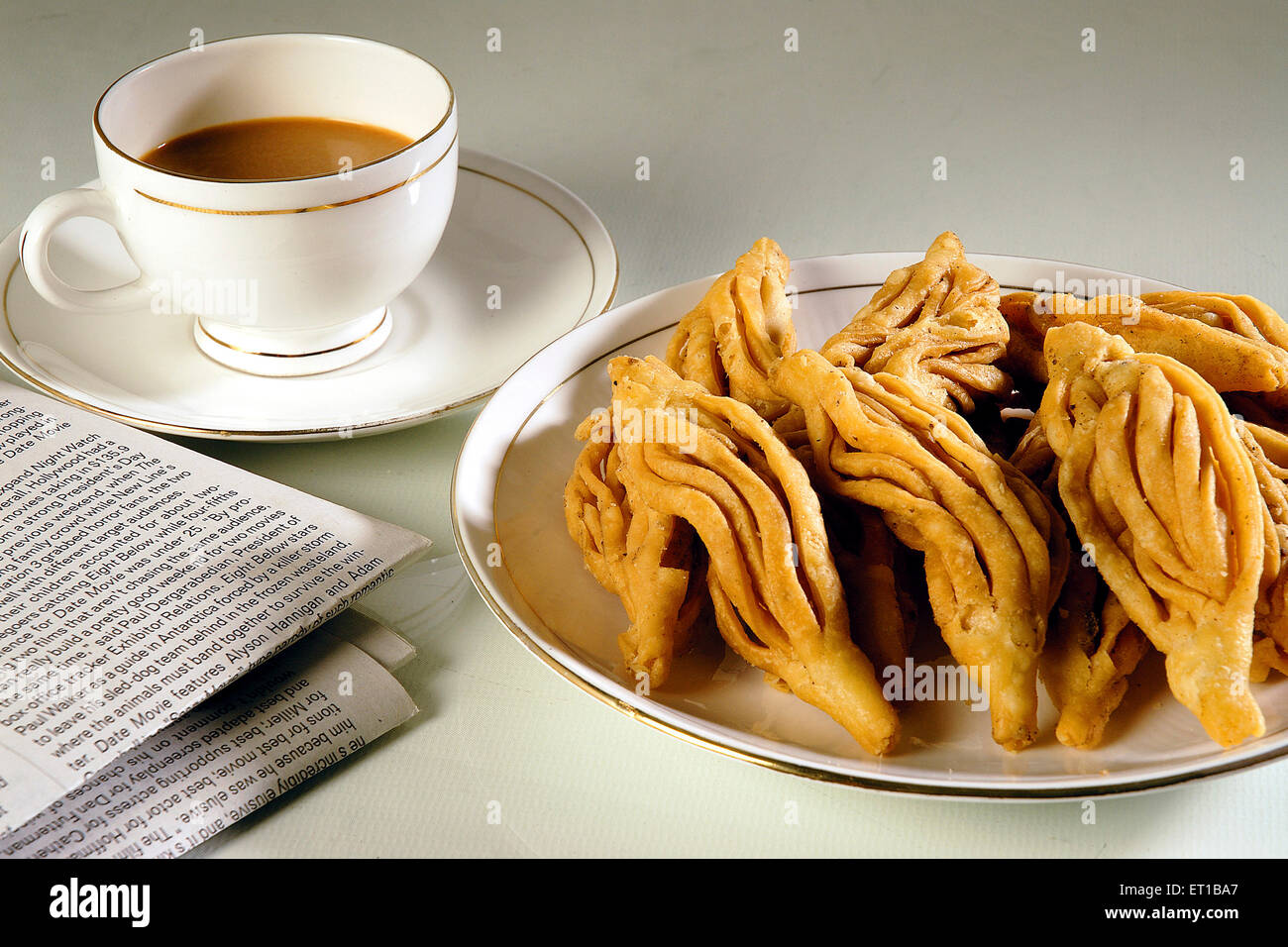 Snacks ; namkeen maida karela with tea on white background ; Jodhpur ...