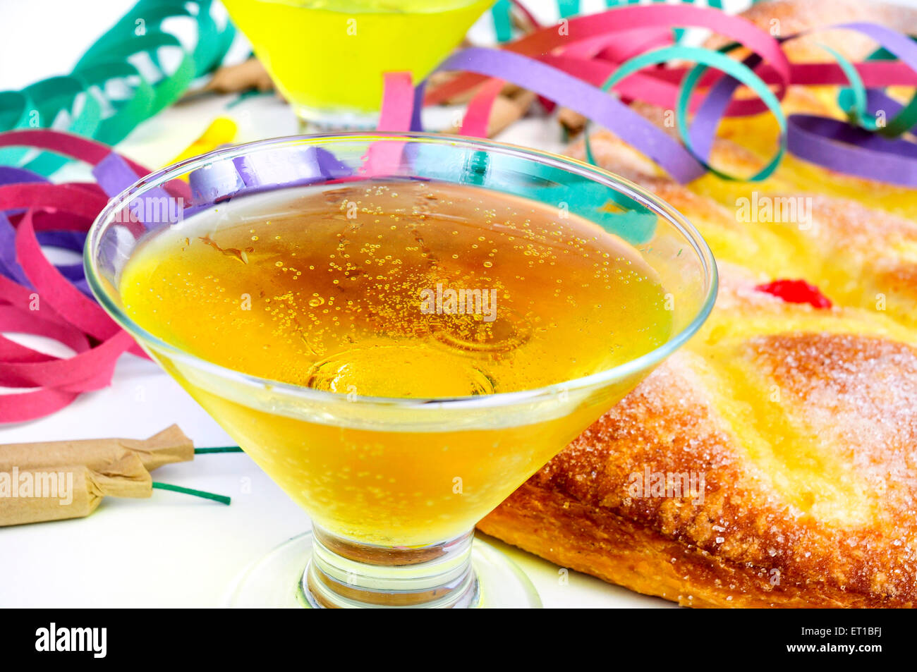 closeup of two glasses with champagne, some firecrackers and streamers ...