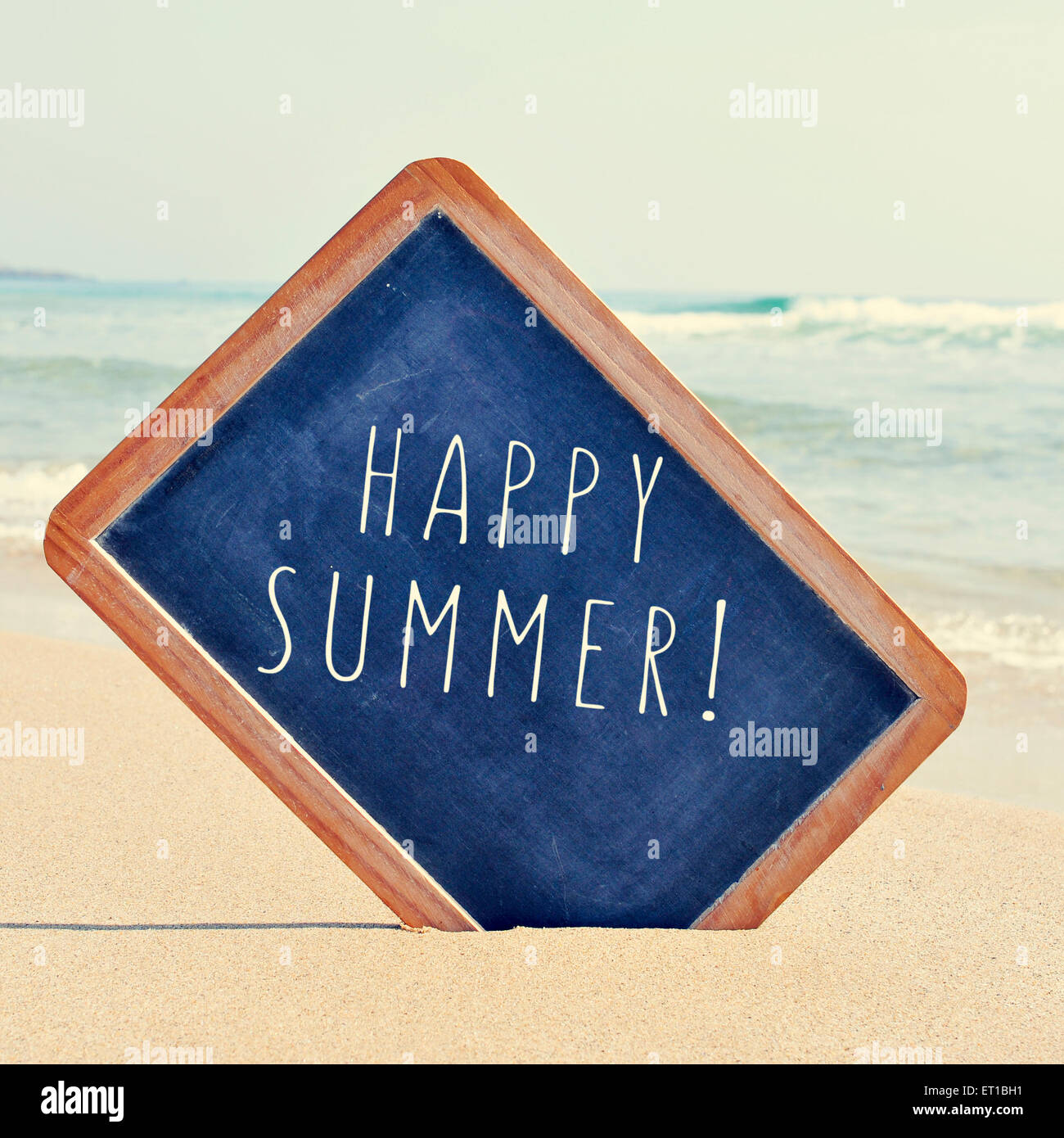 closeup of a chalkboard with a wooden frame and the text happy summer ...