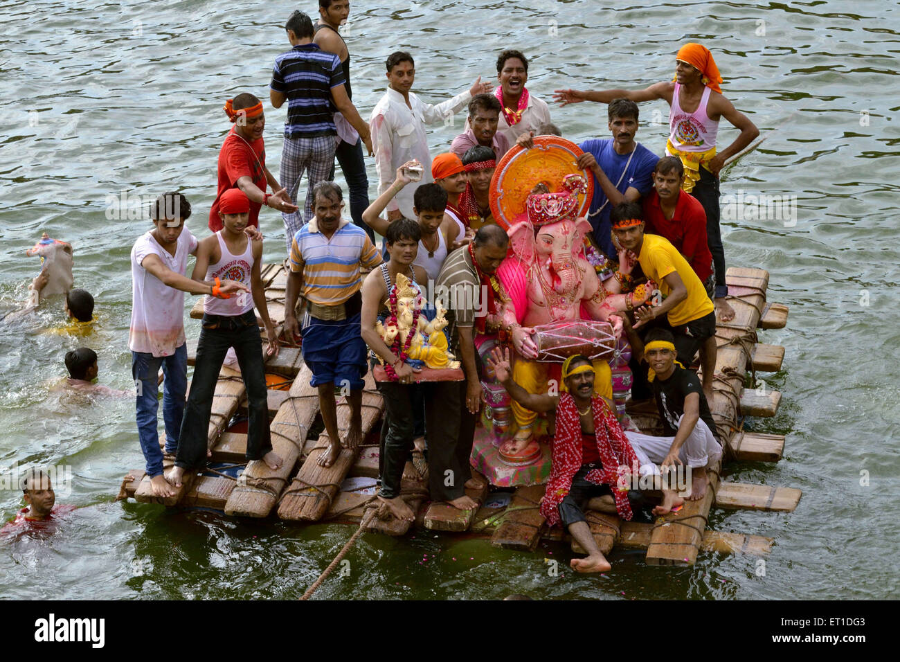 Volunteers carrying idol of Ganesh Ji on floating raft Ganpati Visarjan ...