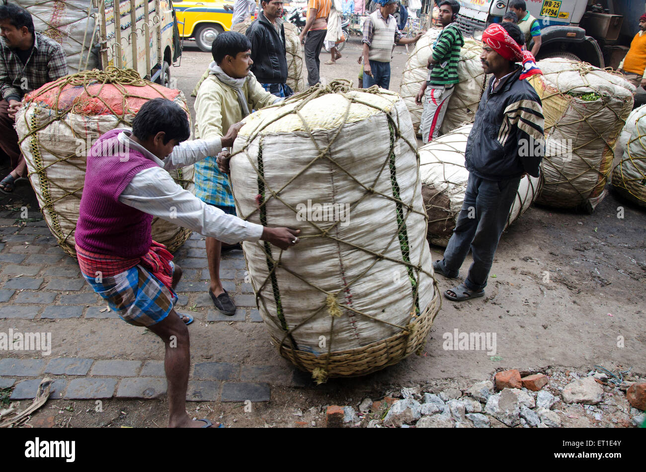 Workers tying heavy sack on road Kolkata West Bengal India Asia Stock ...