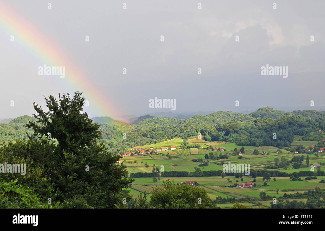 Rainbow raising over the valley Stock Photo - Alamy
