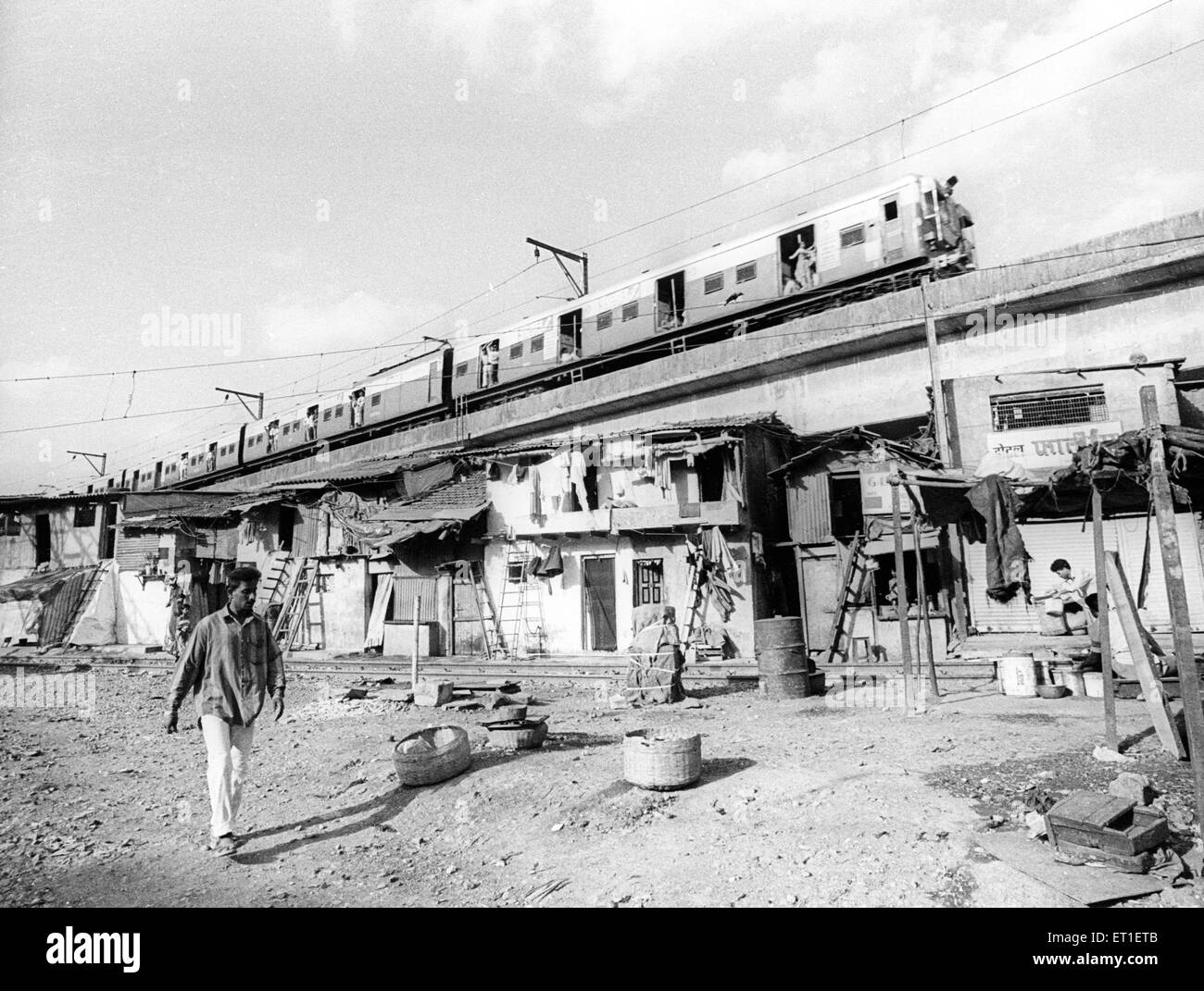 Local train and slum at Wadala ; Bombay Mumbai ; Maharashtra ; India ...