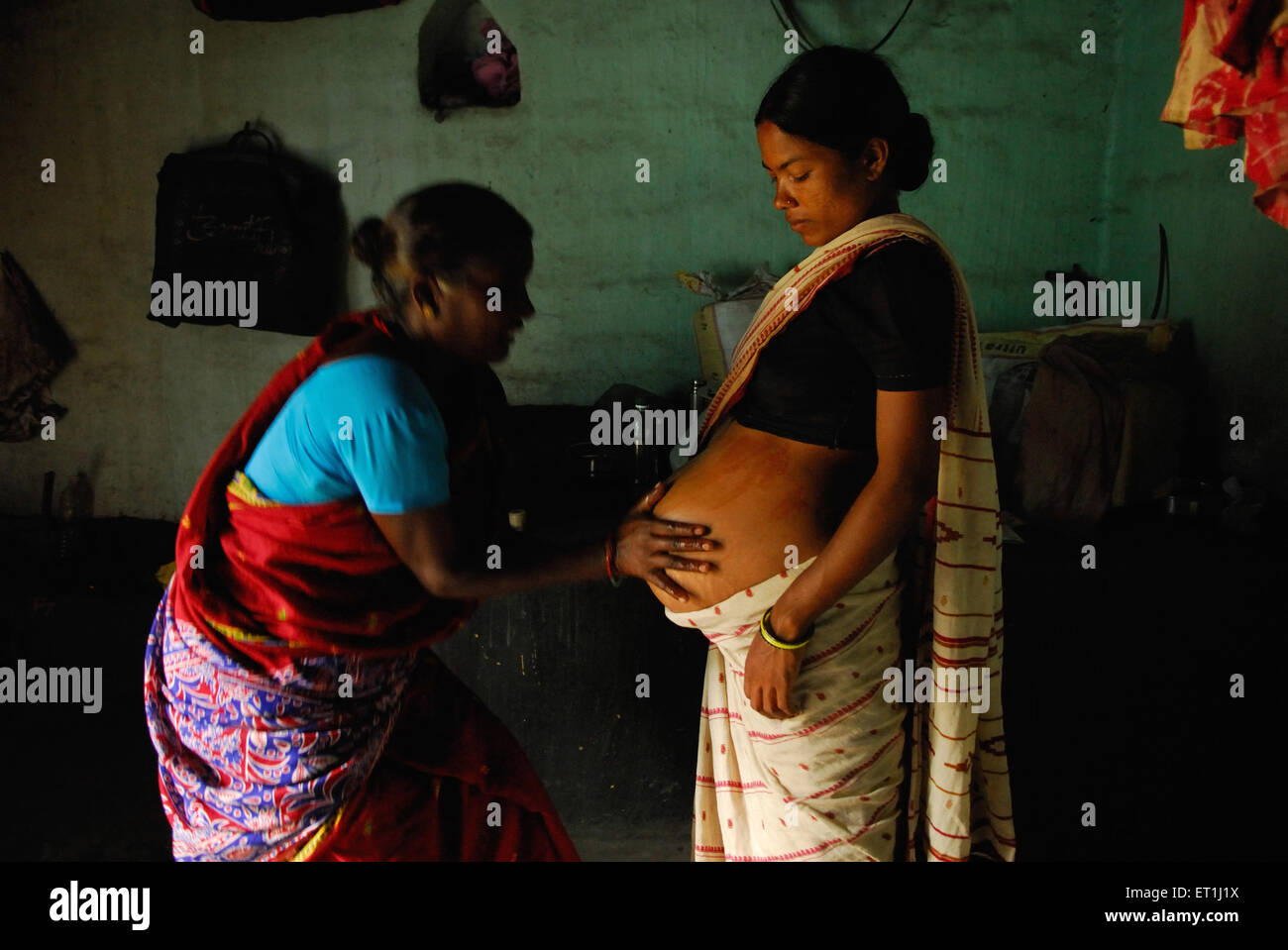 applying oil pregnant woman stomach, Ho tribe, tribal people ...