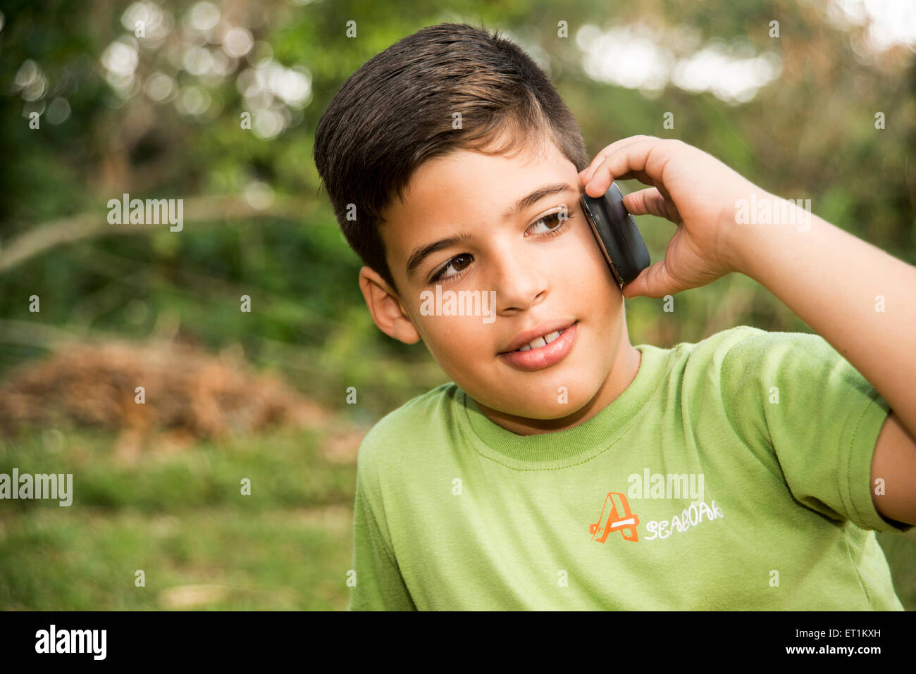 Young Latin boy talking on cell phone Stock Photo - Alamy