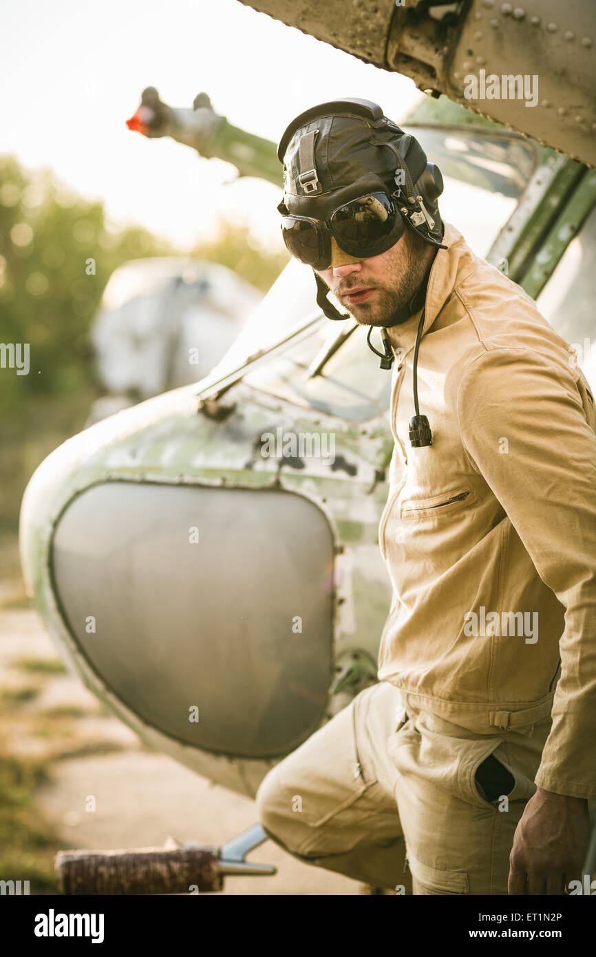 Young serious pilot posing near the helicopter Stock Photo - Alamy