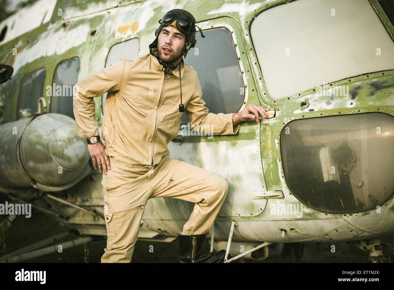Young serious pilot posing near the helicopter Stock Photo - Alamy