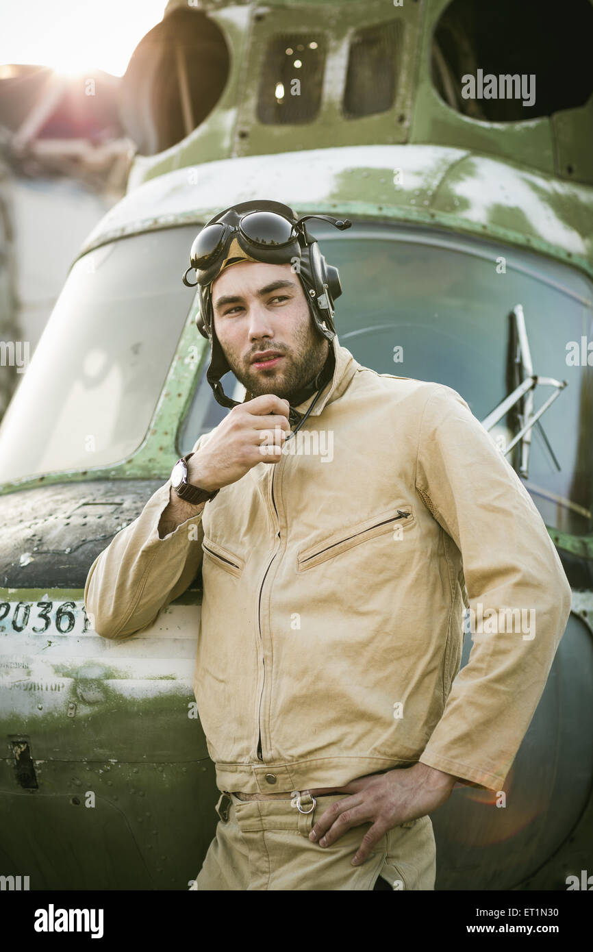 Young serious pilot posing near the helicopter Stock Photo - Alamy