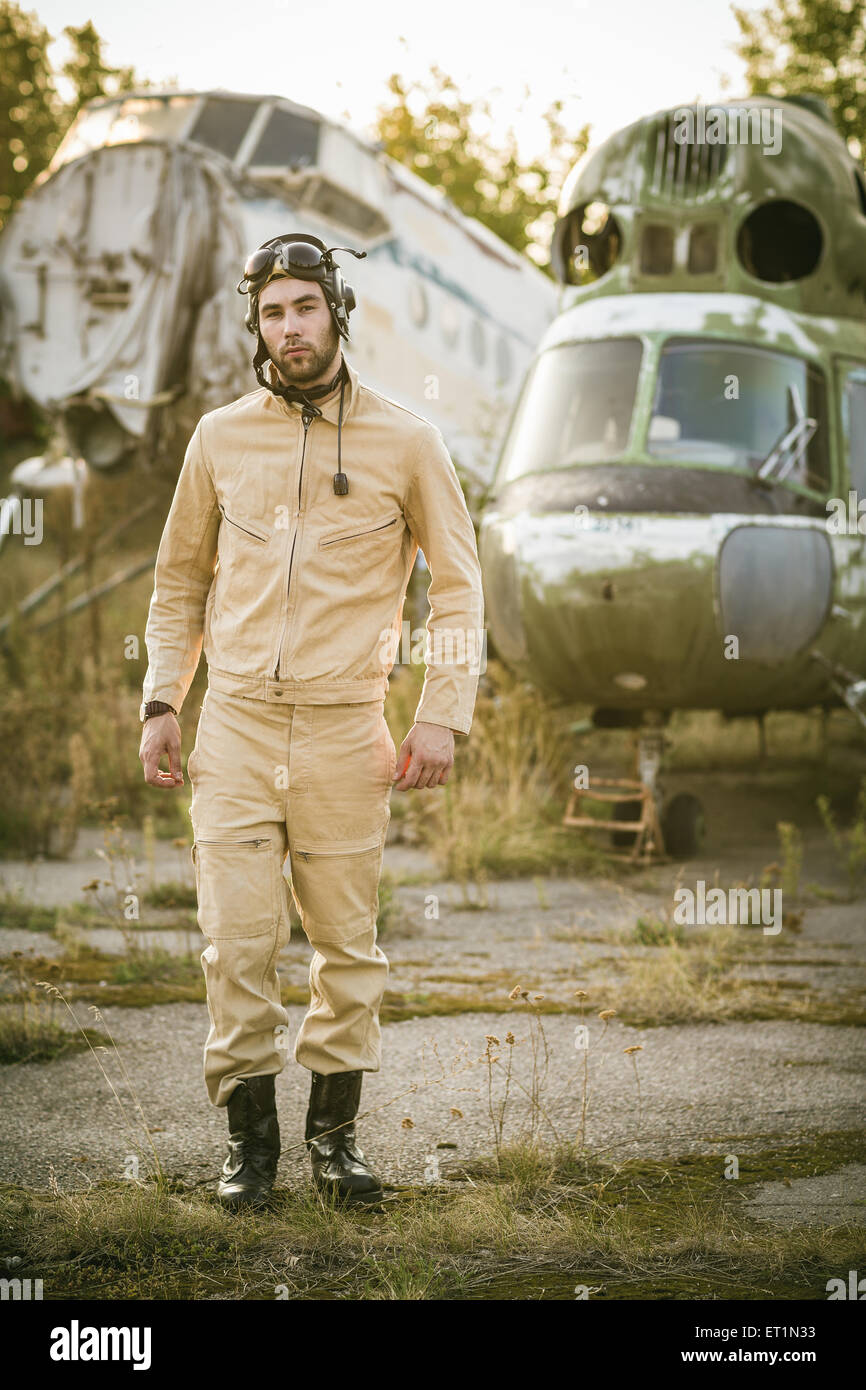 Young serious pilot posing near the helicopter Stock Photo - Alamy