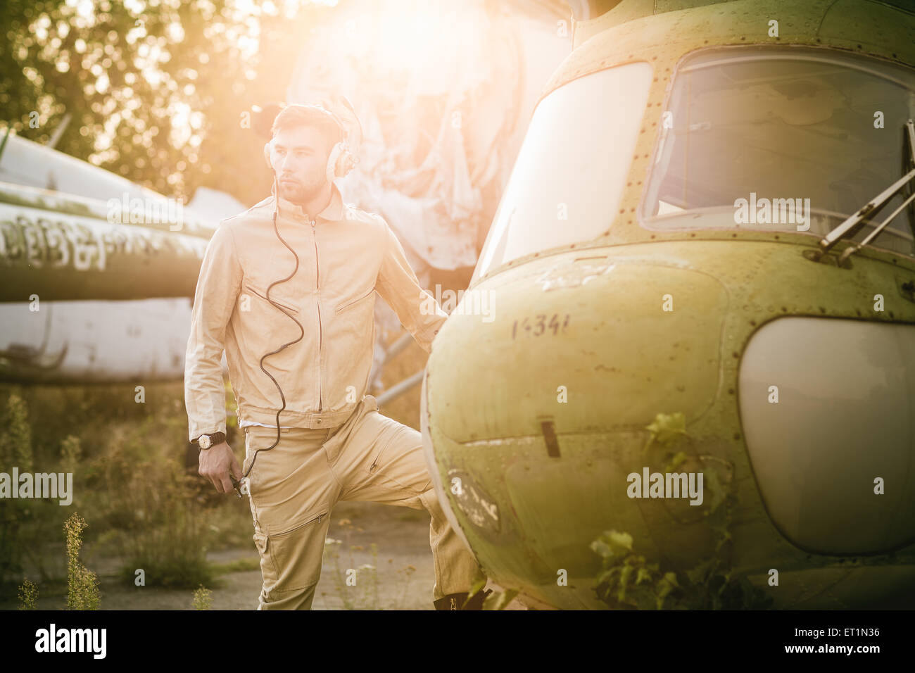 Young serious pilot posing near the helicopter Stock Photo - Alamy