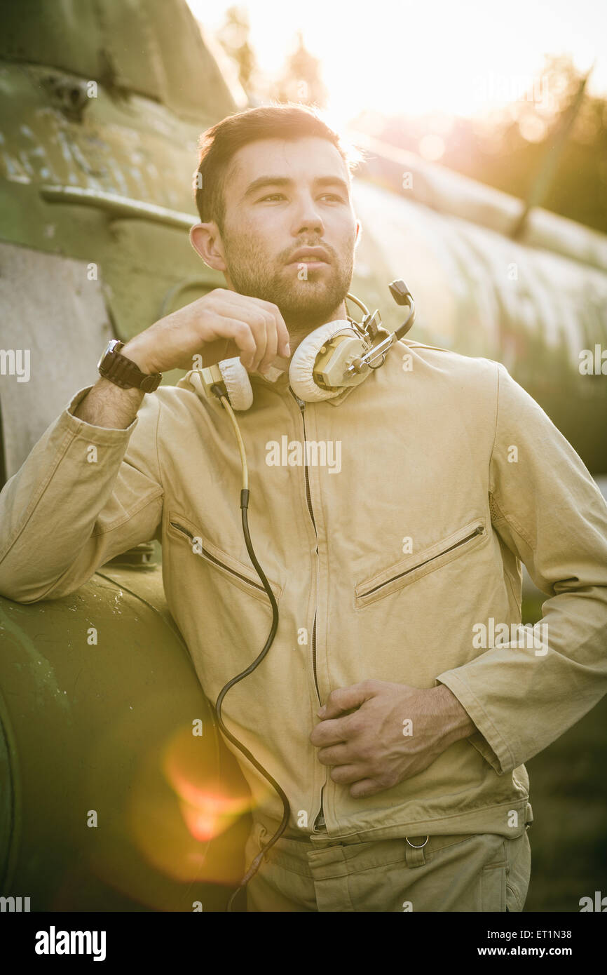 Young serious pilot posing near the helicopter Stock Photo - Alamy