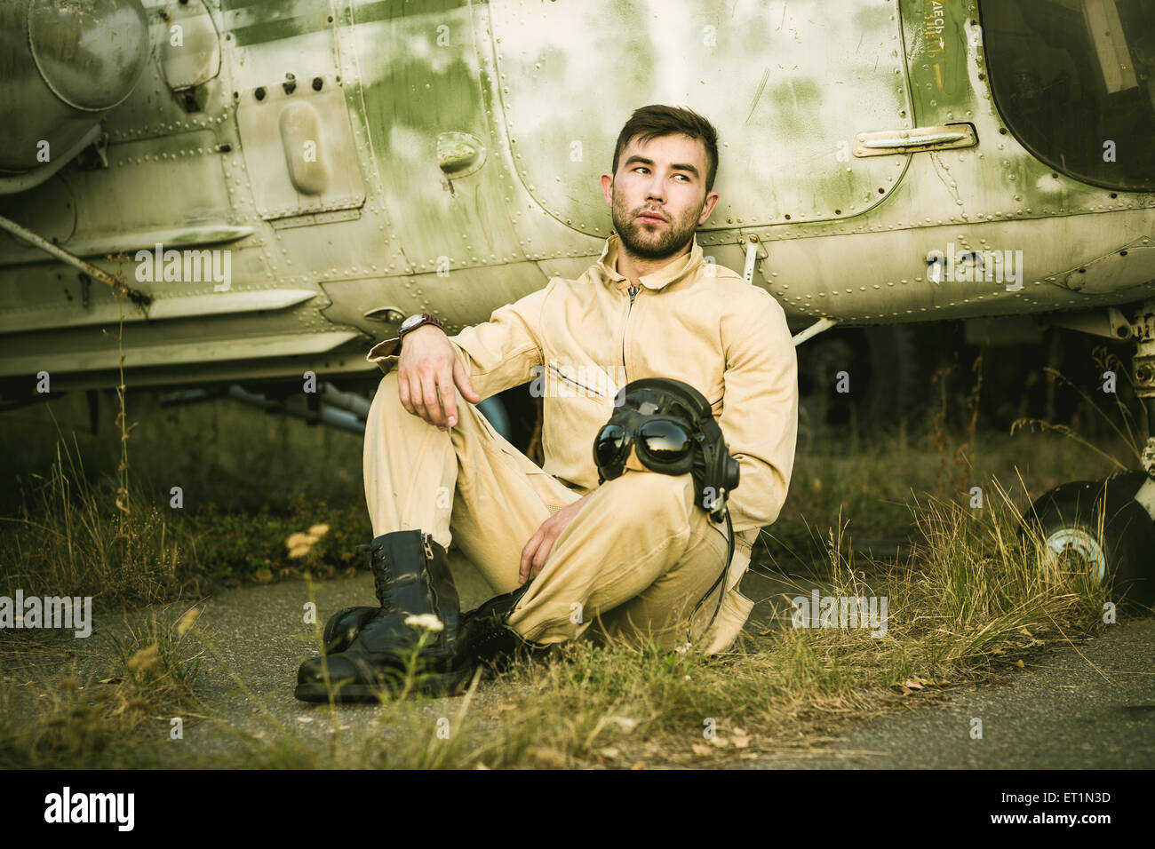 Young serious pilot posing near the helicopter Stock Photo - Alamy
