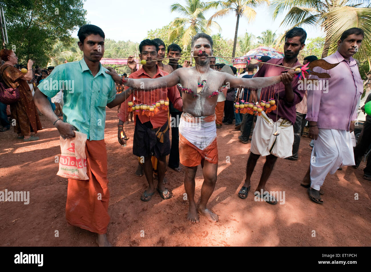 Man piercing spike through cheeks discharging vow in Thaipusam festival ...