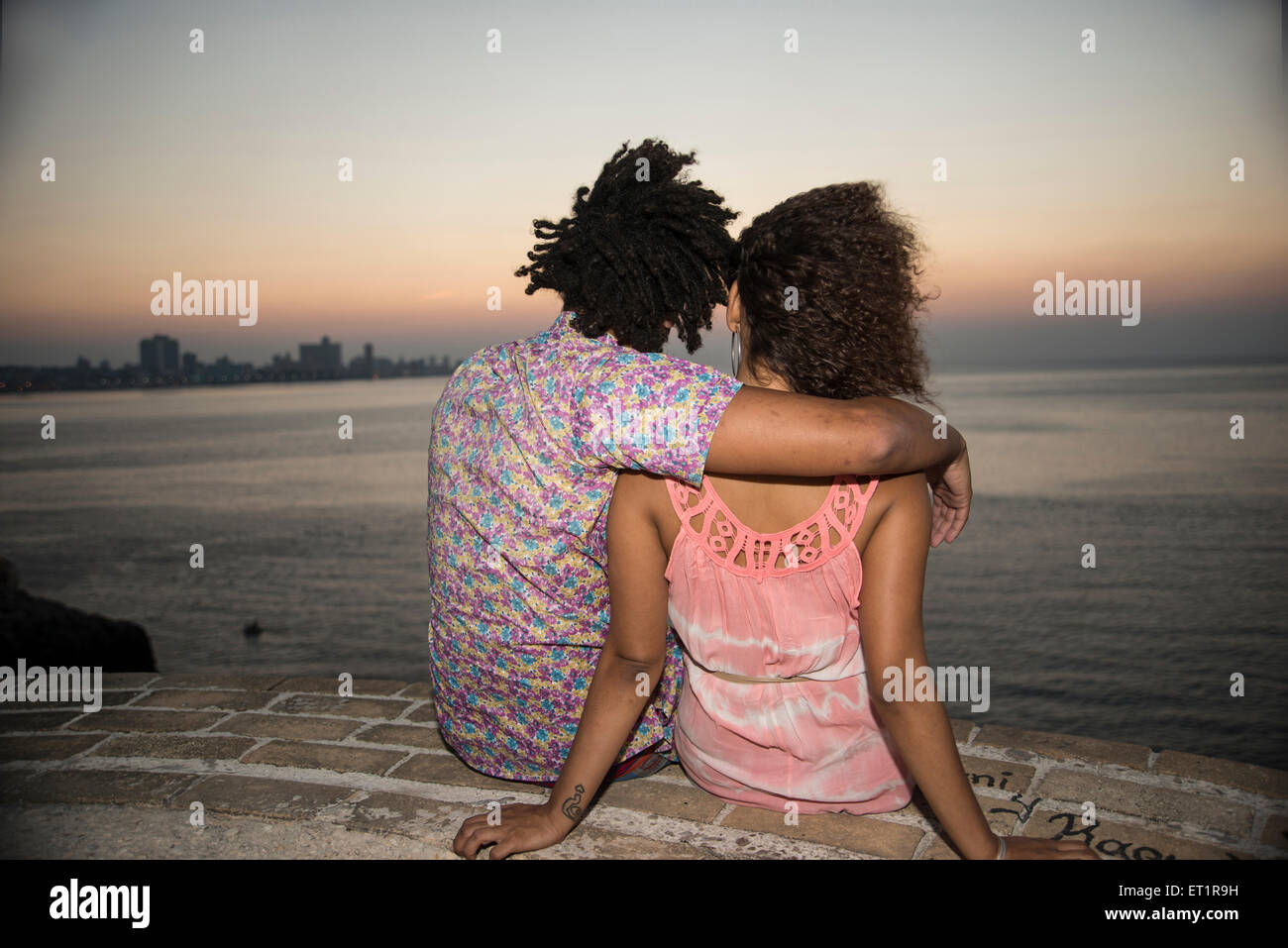 Latin couple watching a sunset Stock Photo - Alamy