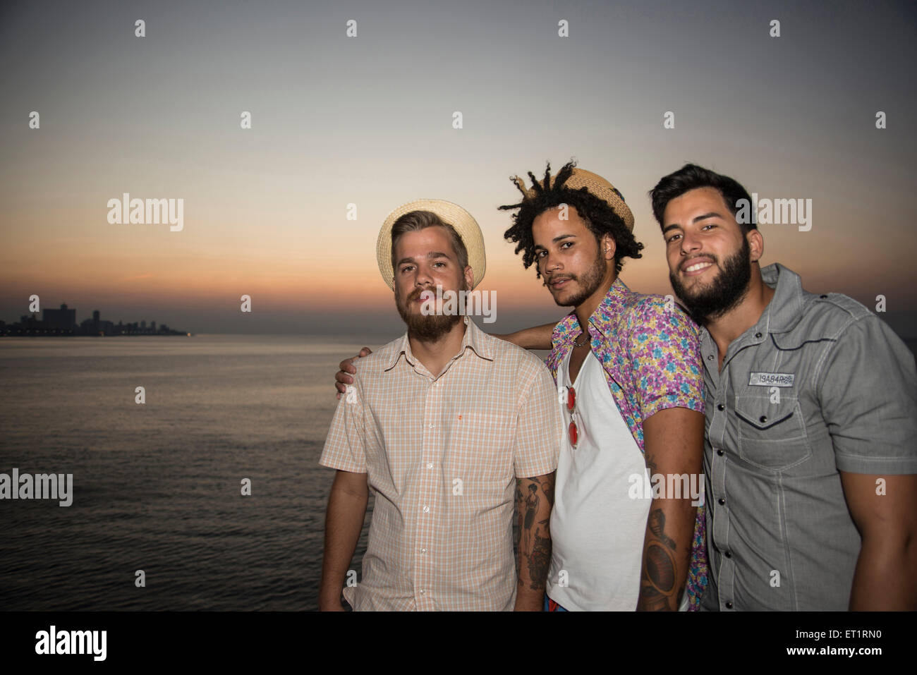Three friends watching a sunset Stock Photo - Alamy
