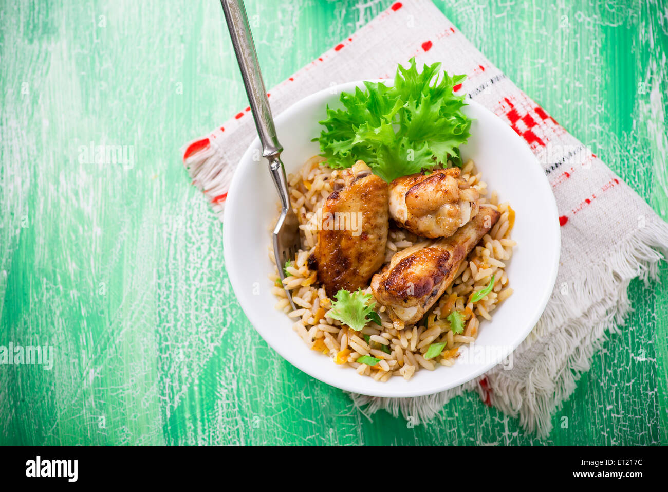 Baked chicken wings with rice in a bowl, top view, selective focus ...