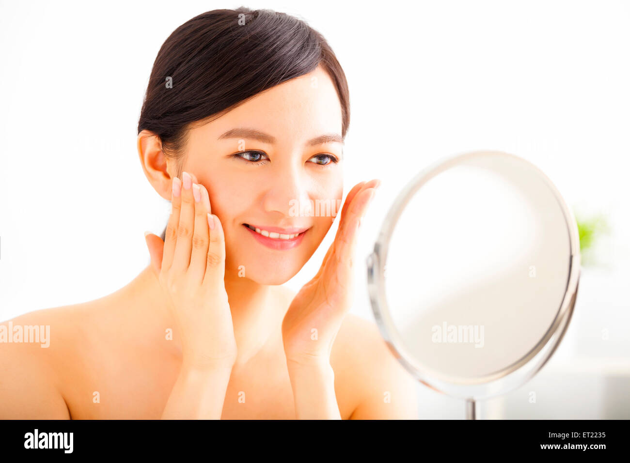 Happy young woman looking on mirror Stock Photo - Alamy