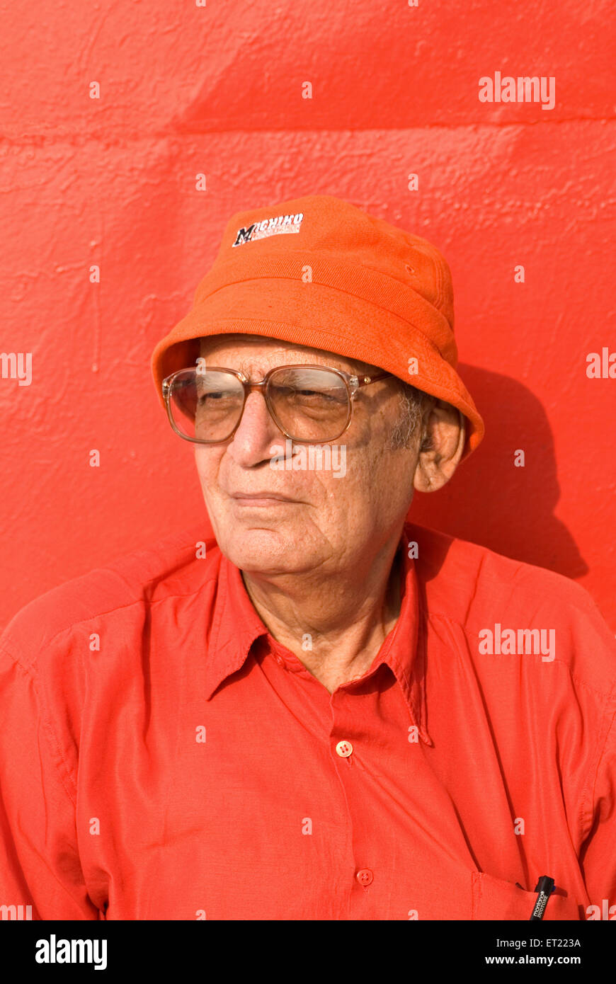 red cap ; red shirt ; red background ; Cyrus Shroff ; Bombay ; Mumbai ...