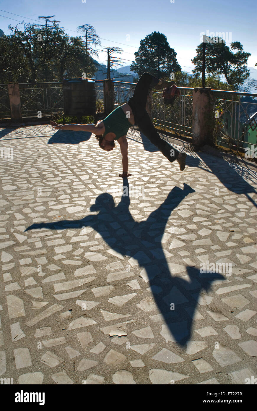 French acrobat doing one arm handstand act to create play of shadows ...