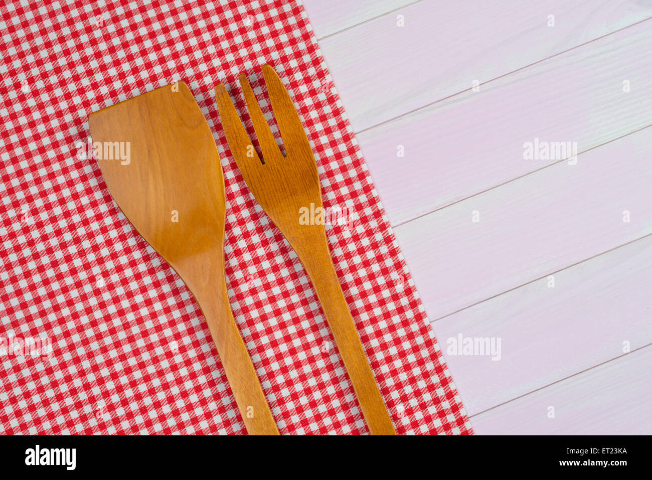Kitchenware on white and red towel over wooden kitchen table. View from ...