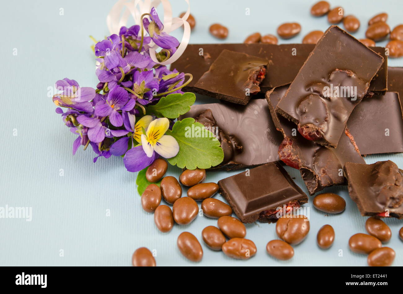 Dark chocolate with raisins, chocolate balls and a cup of coffee on a ...