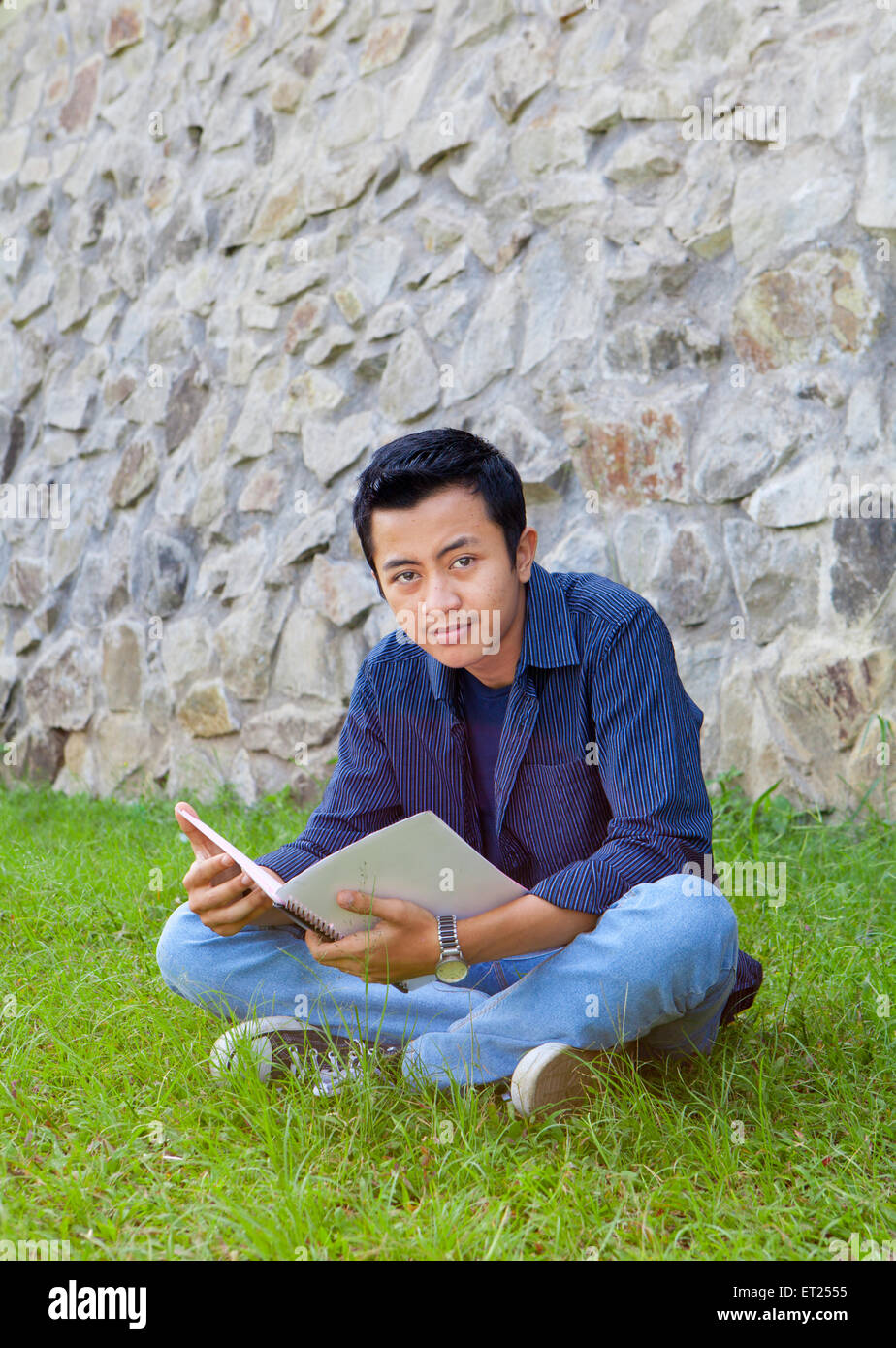 Young boy reading book in the park outdoor Stock Photo - Alamy