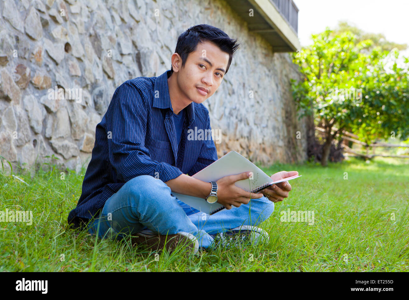 Young boy reading book in the park outdoor Stock Photo - Alamy