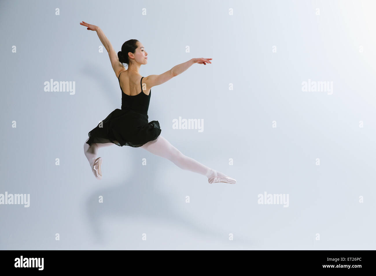 Rear view of young female ballet dancer standing by handrail in ...