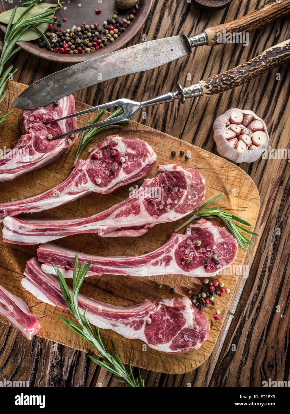 Raw lamb chops with garlic and herbs on the old wooden table Stock ...
