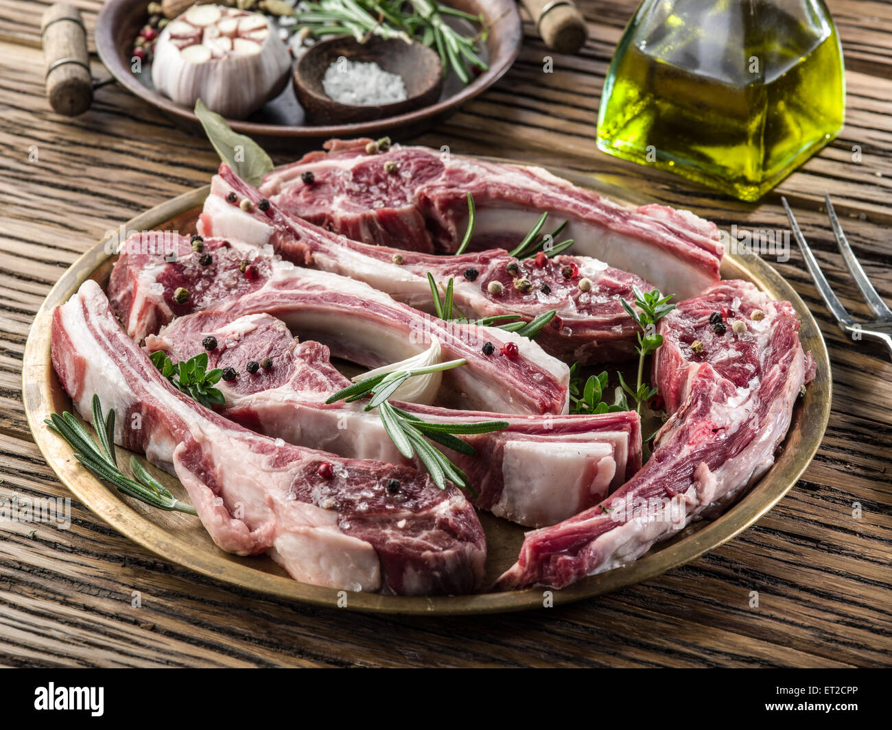 Raw lamb chops with garlic and herbs on the old wooden table Stock ...
