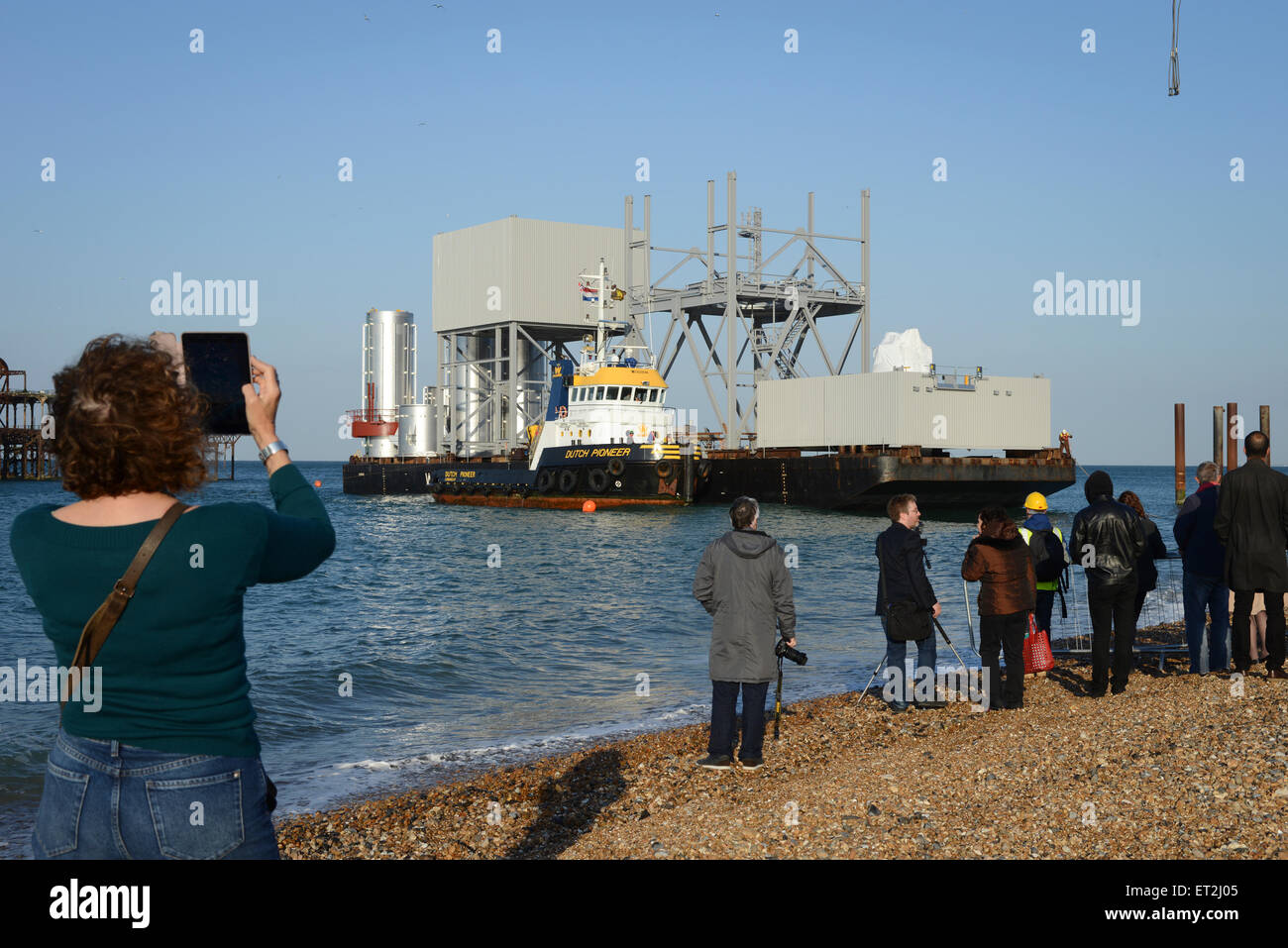 People watch and take photos as a large barge containing parts of the ...