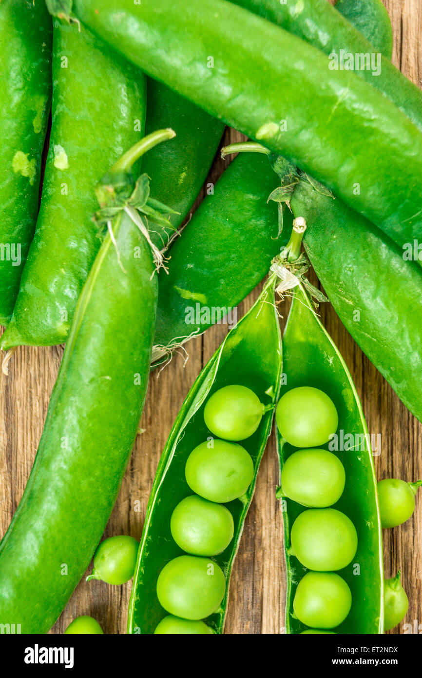 Many raw open pea on wood table Stock Photo - Alamy