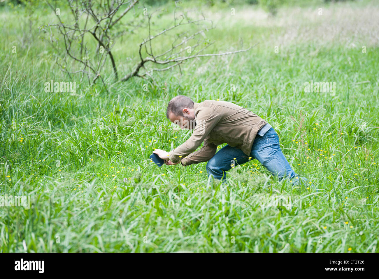 A man taking a photograph using a mobile phone camera in the ...