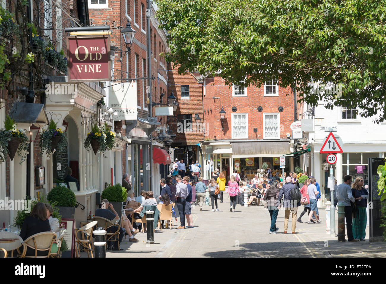 A pretty street in Winchester UK in summer with people walking and ...