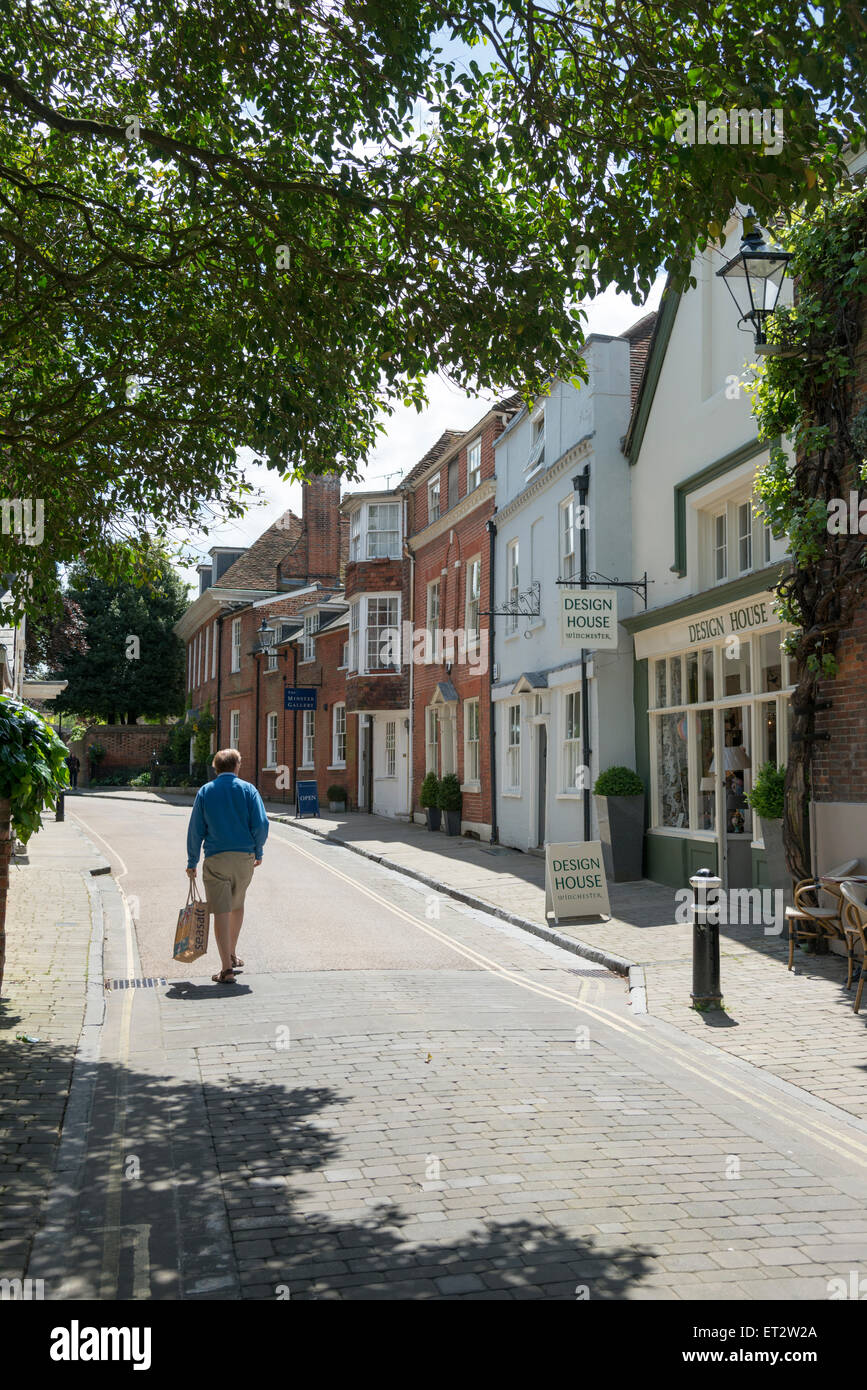 A pretty street in Winchester UK in summer with people walking and ...