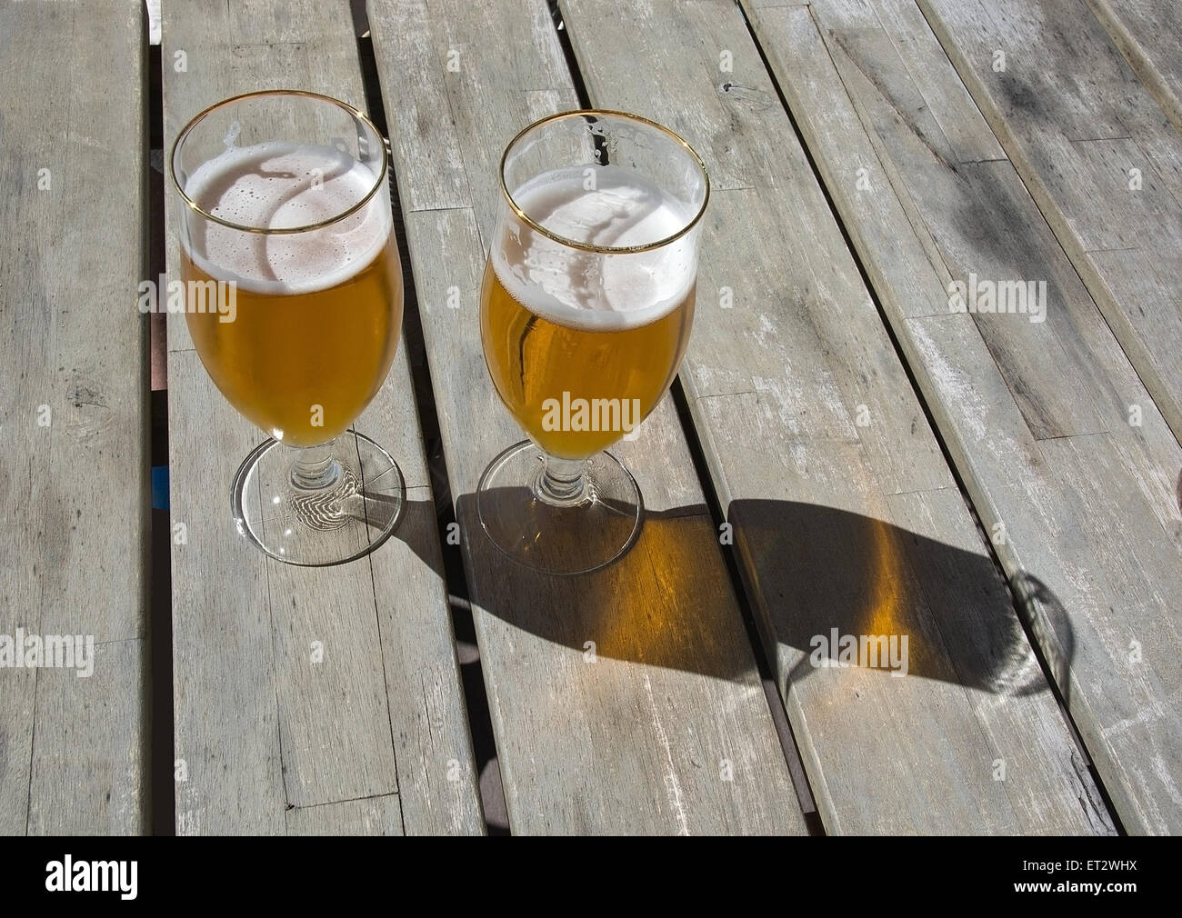Two beers on rustic wooden table outdoors in sunshine Stock Photo - Alamy