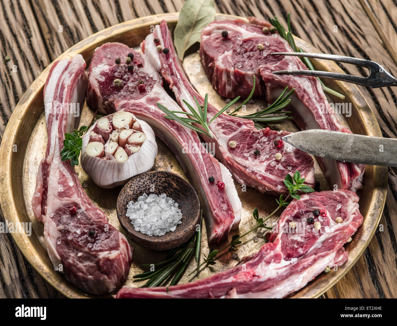 Raw lamb chops with garlic and herbs on the old wooden table Stock ...