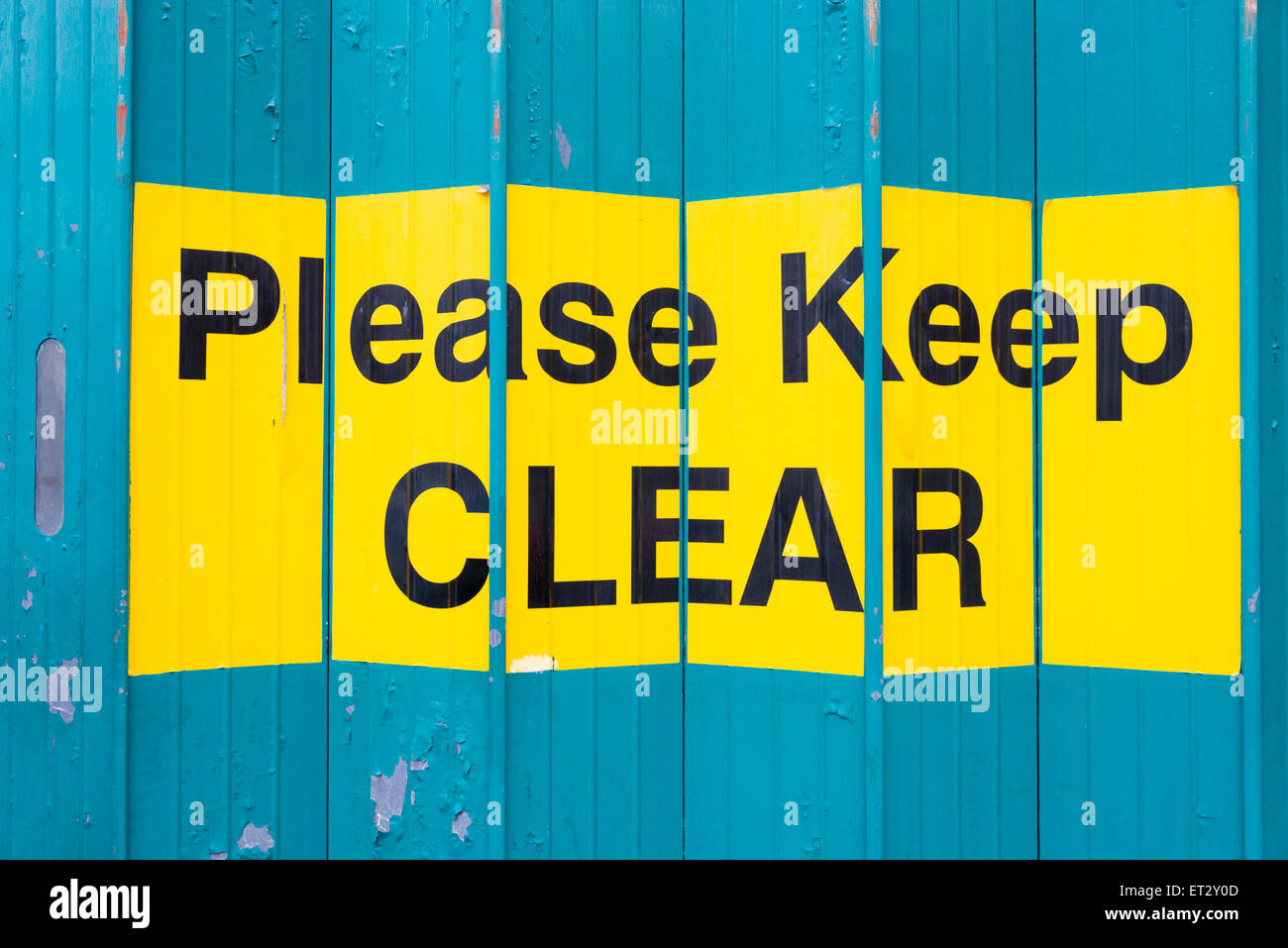 A please keep clear sign on a folding door on a commercial building ...