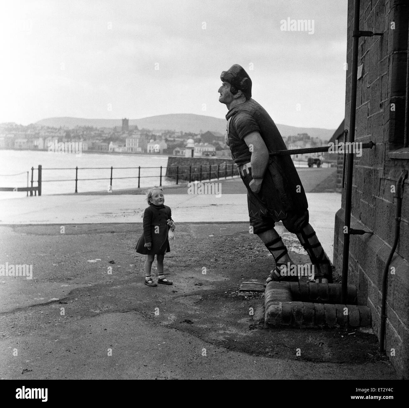 Little Susan Bond, 4, looks at the wooden figurehead of the Saint ...