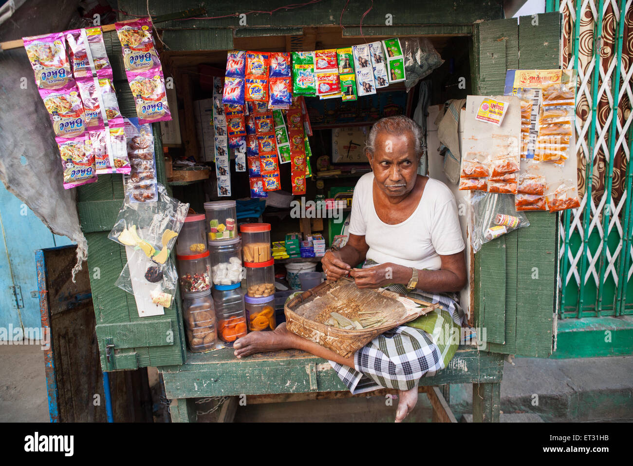 A man making beedis (traditional Indian cigarettes) in his booth in ...