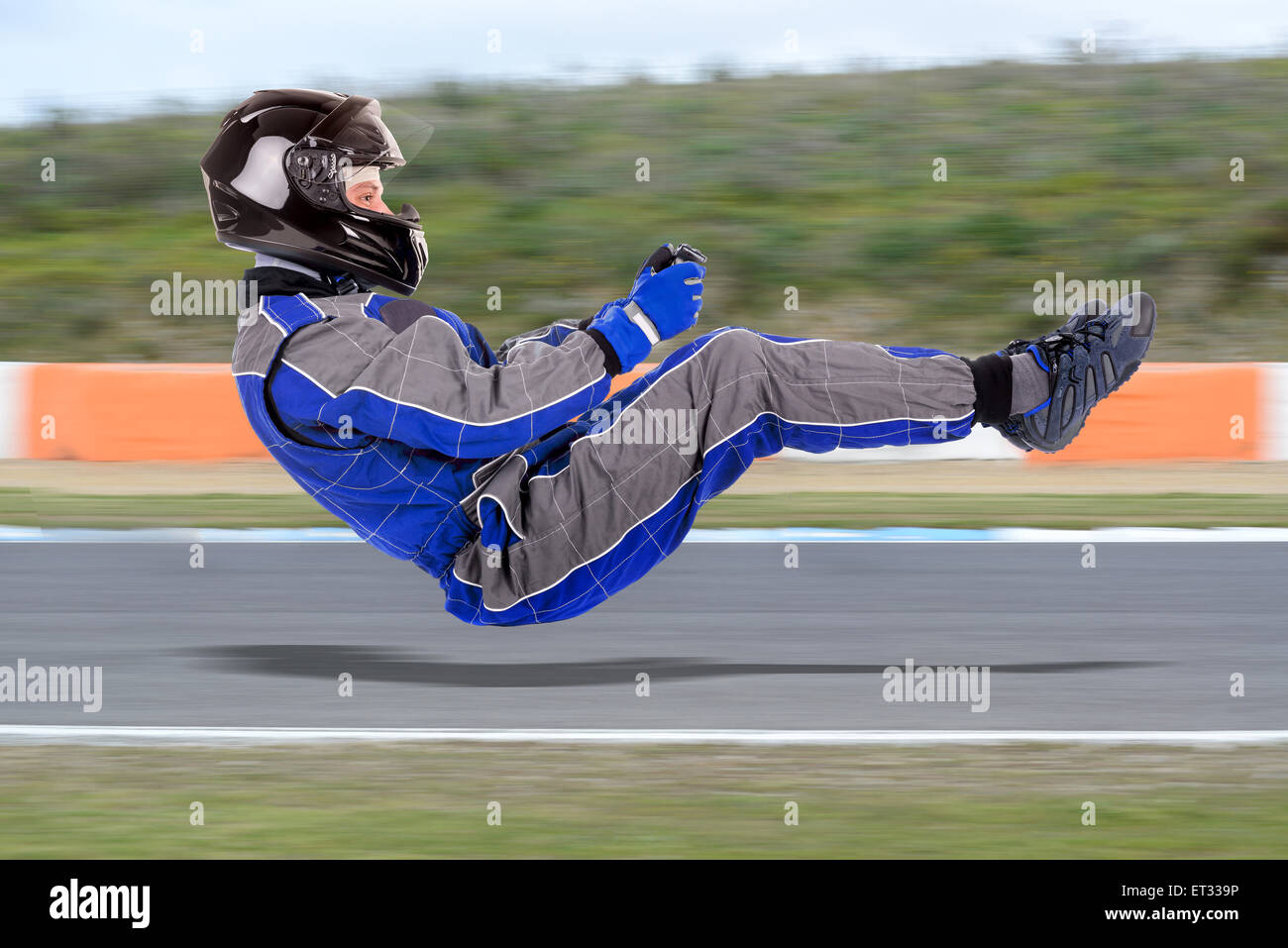 Racing driver on track in driving position in full gear Stock Photo - Alamy