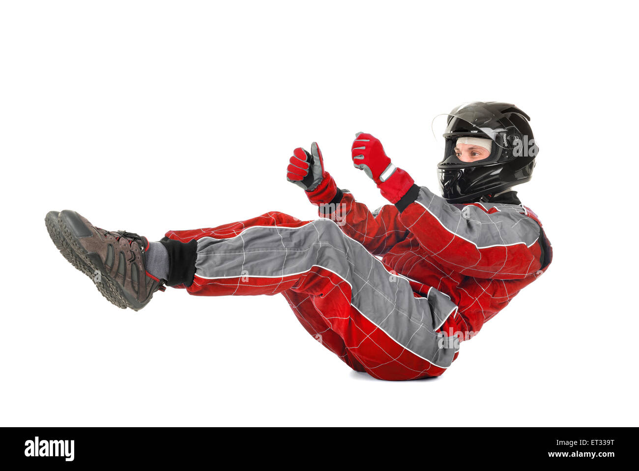 Racing driver posing in driving position in full gear isolated in white ...