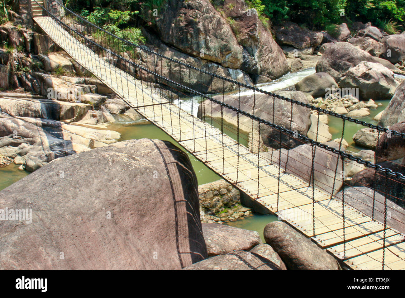 Suspension bridge in a valley above the river Stock Photo - Alamy