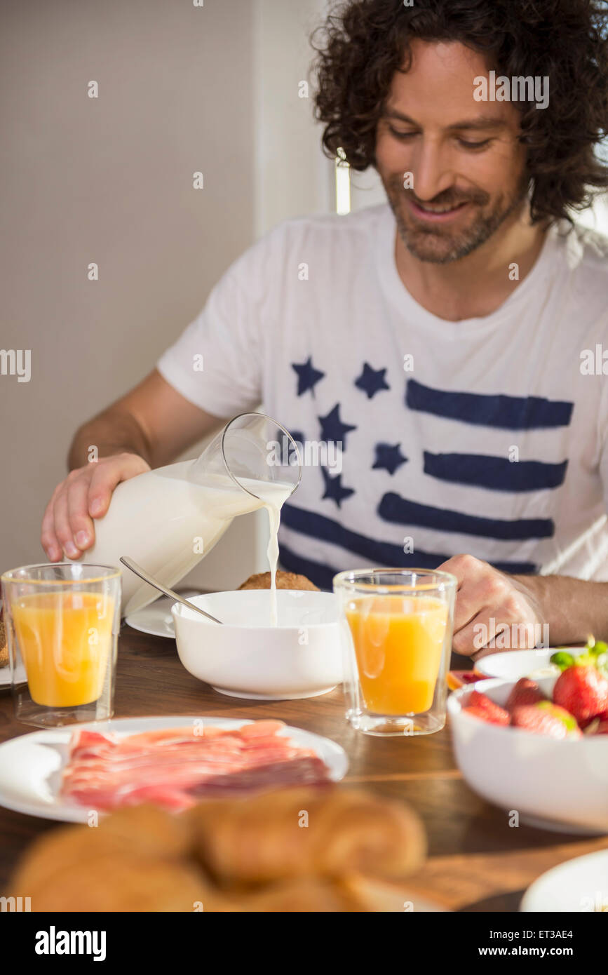 Mid adult man having breakfast at dining table, Munich, Bavaria ...